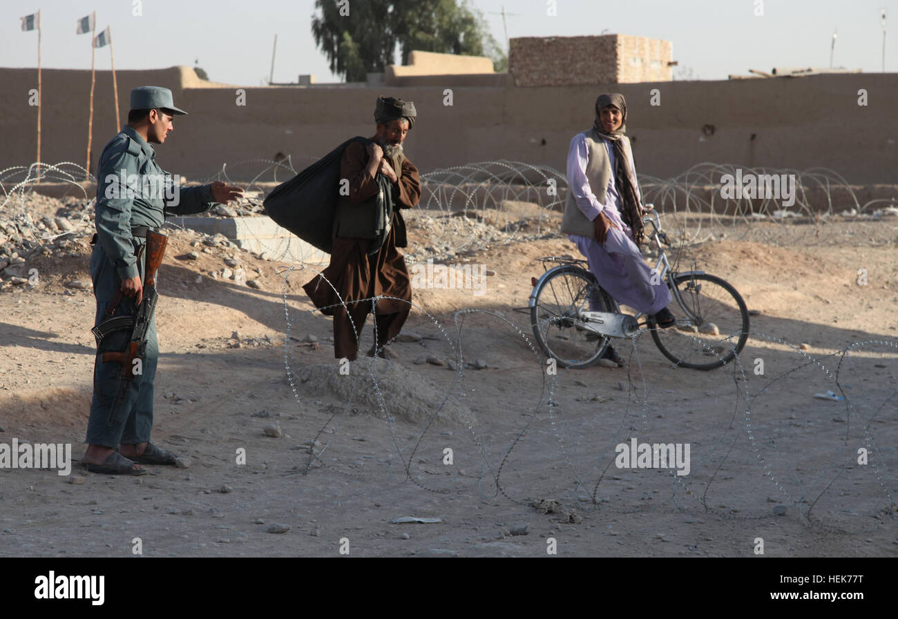 A member of the Afghan National Police (ANP), left, directs Afghan men ...