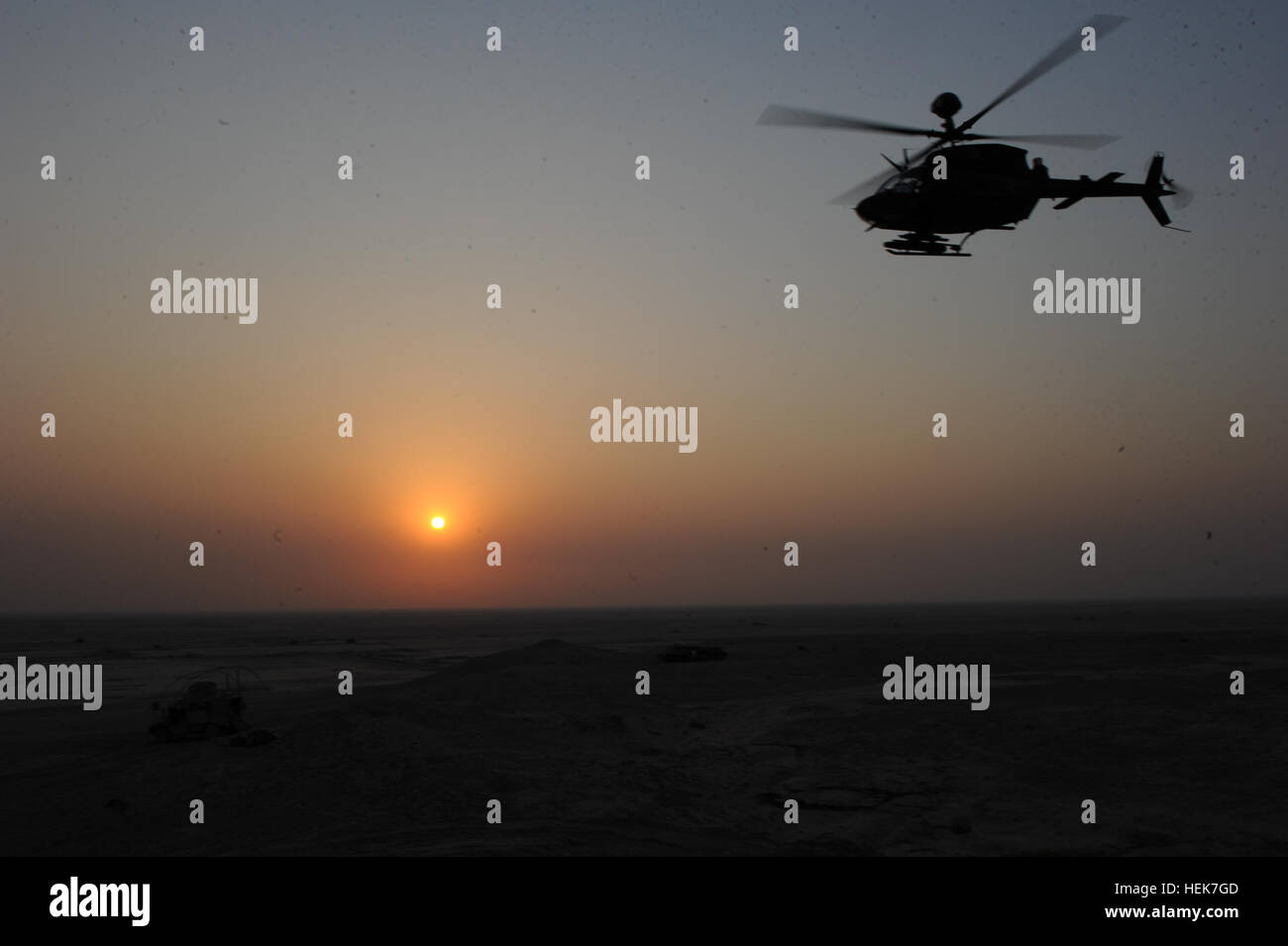 U.S. soldiers maneuver an OH-58 Kiowa Warrior across the desert of ...