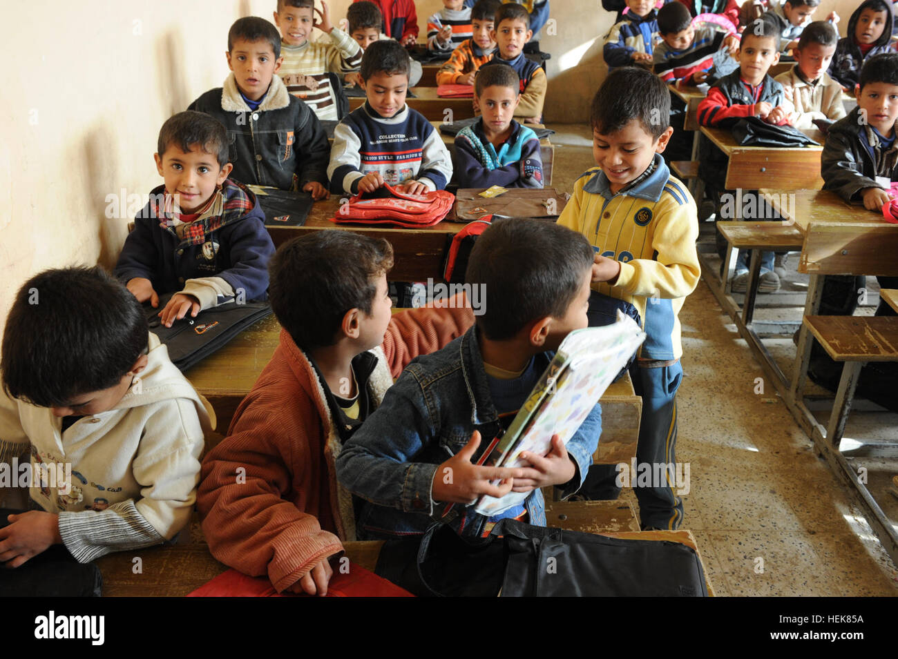 Iraqi school children excitedly examine school supplies they received ...