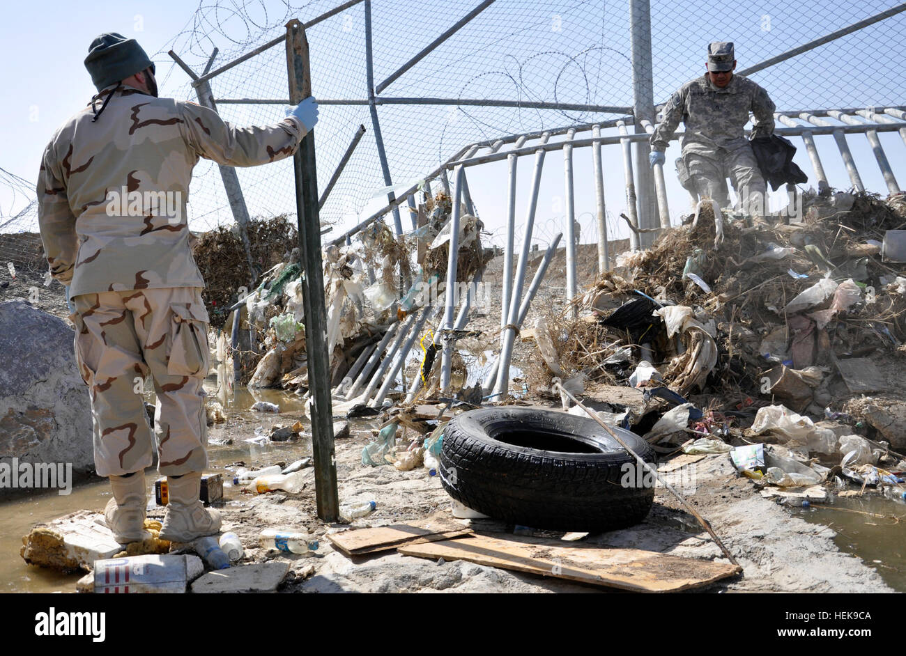 U.S. Army soldiers clear debris from water grates on Kandahar Airfield ...