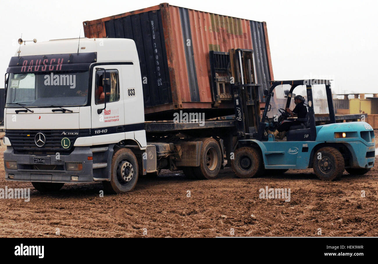 Iraqi workers hoist a repaired container onto a truck to be delivered ...