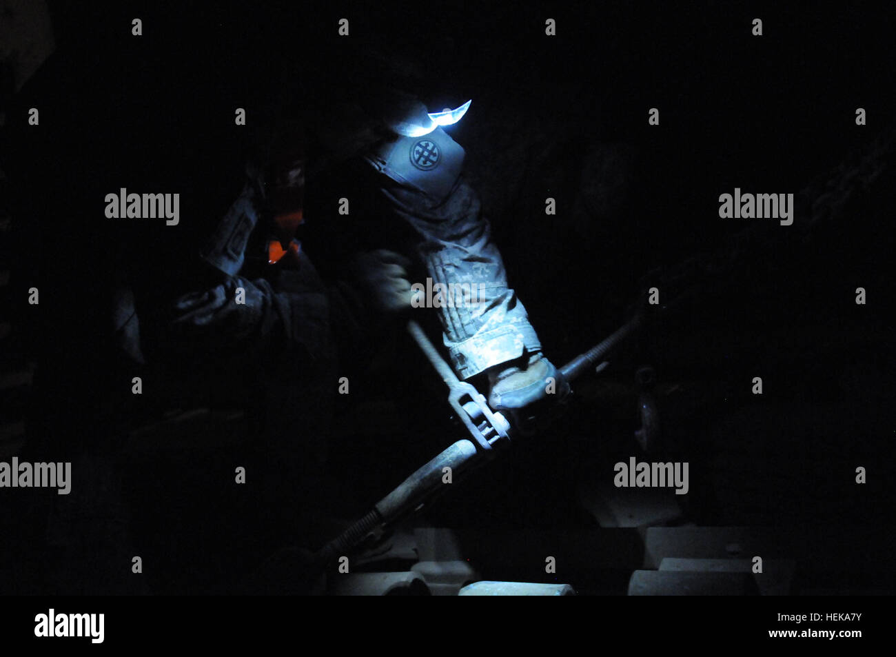 Working by just a single flashlight, Sgt. Jose Garza, a truck commander ...