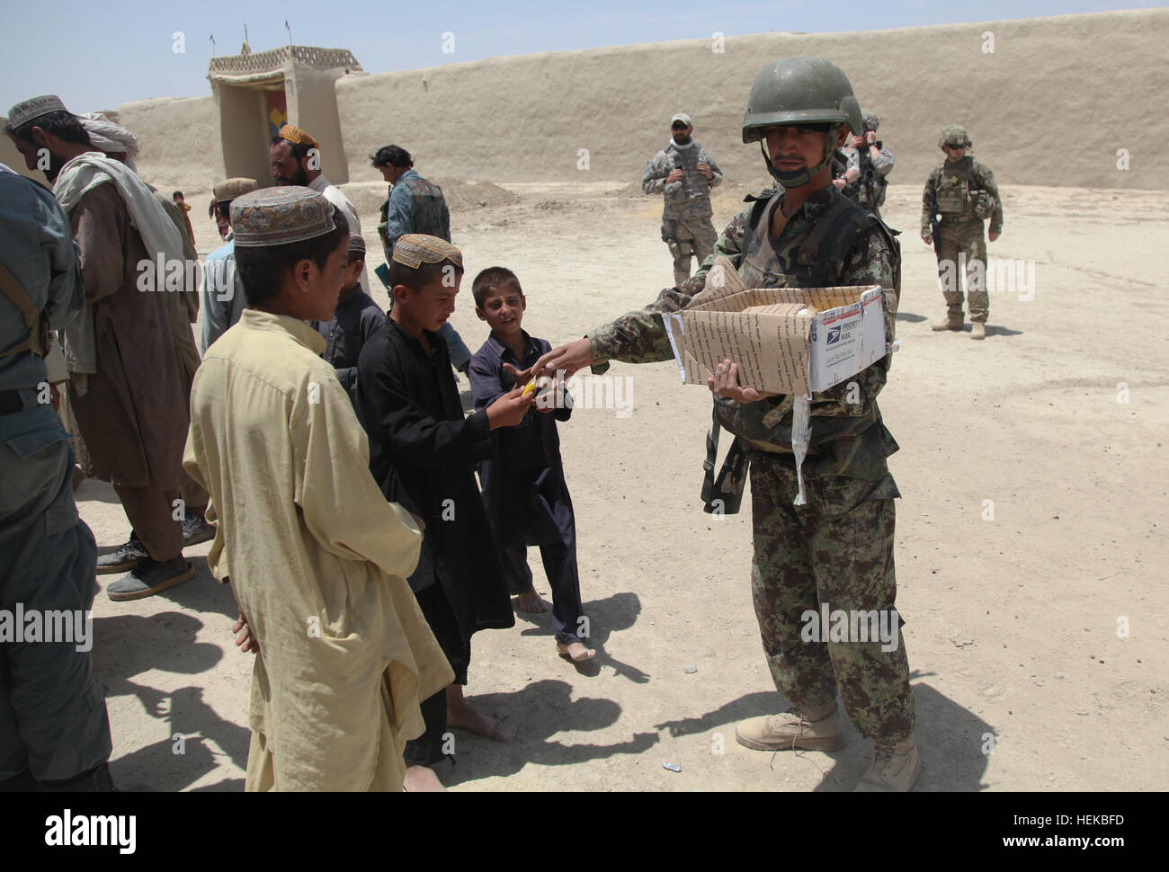 An Afghan National Army soldier hands out hygiene items to the children ...