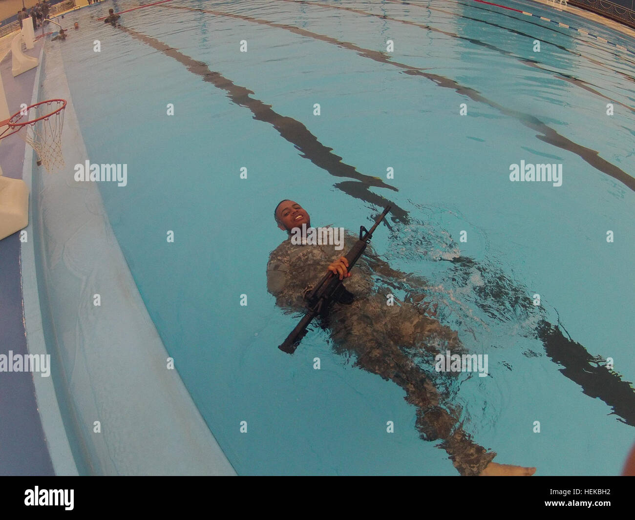 U.S. Army Pvt. Semaj Murphy swims while keeping his weapon above the ...