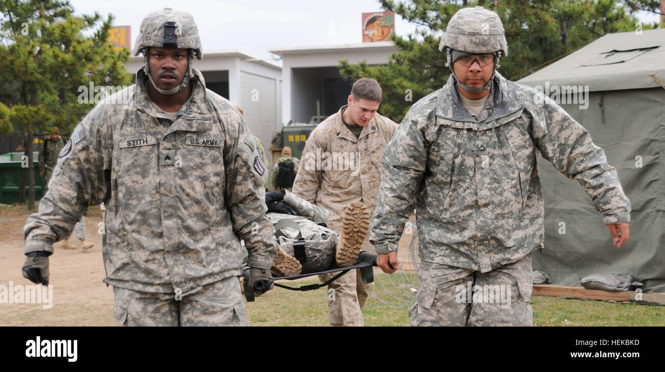 Soldiers and a Marine transport a casualty during a mass casualty ...