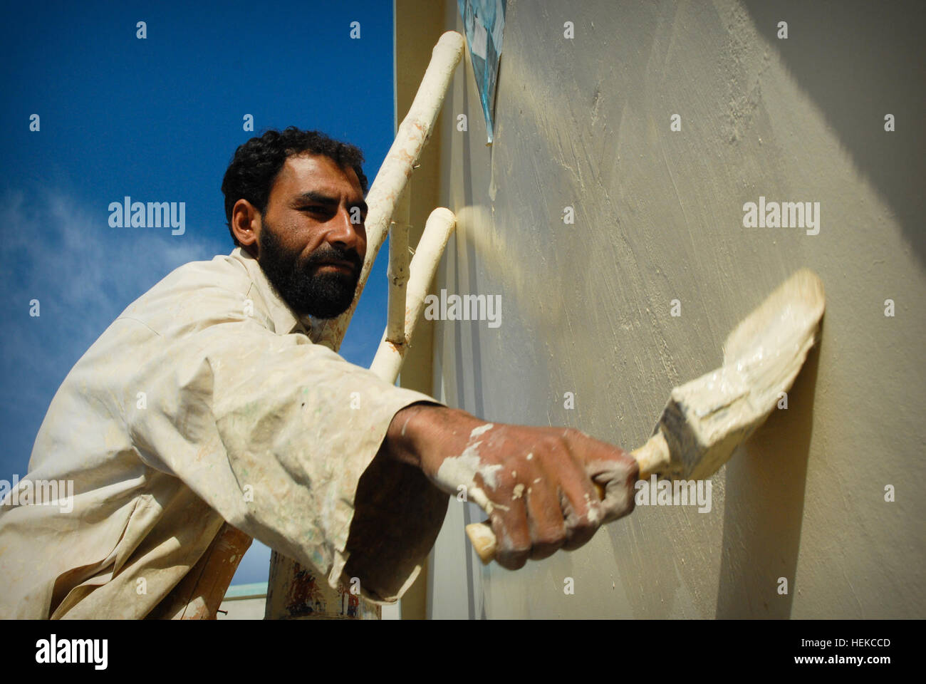 An Afghan man earns money by painting the outside walls of the Shah ...
