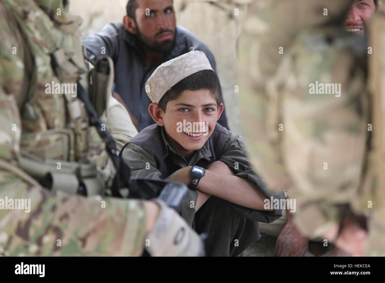 An Afghan boy sits with his father as U.S. Army soldiers question the ...