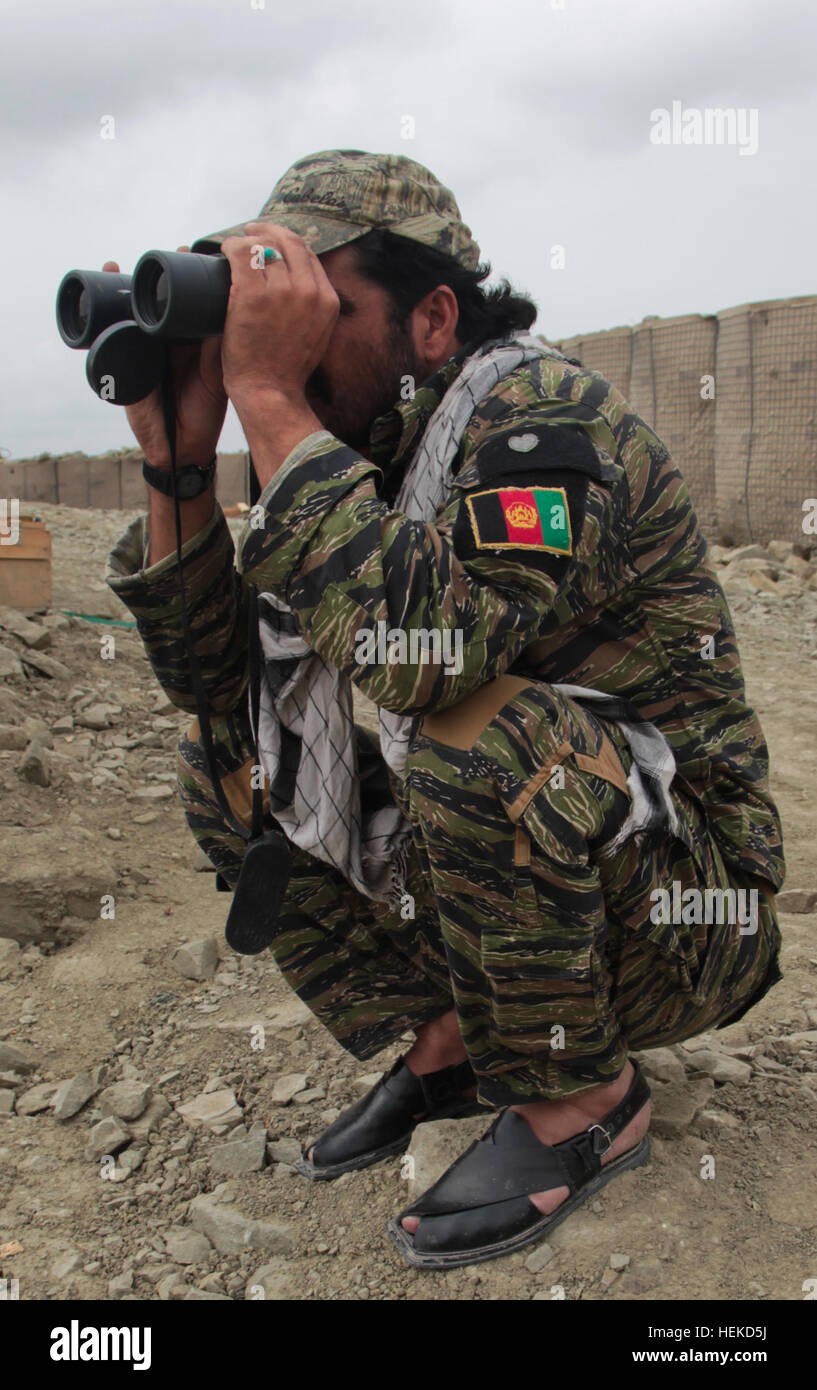 An Afghan Local Policeman monitors suspicious activity in a valley from ...