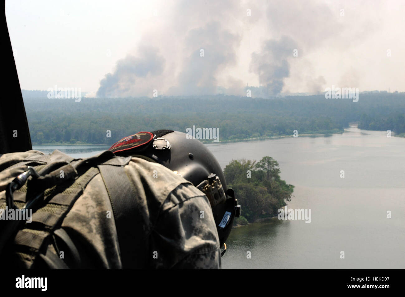 A CH-47 Chinook helicopter crew chief looks down as the aircraft ...