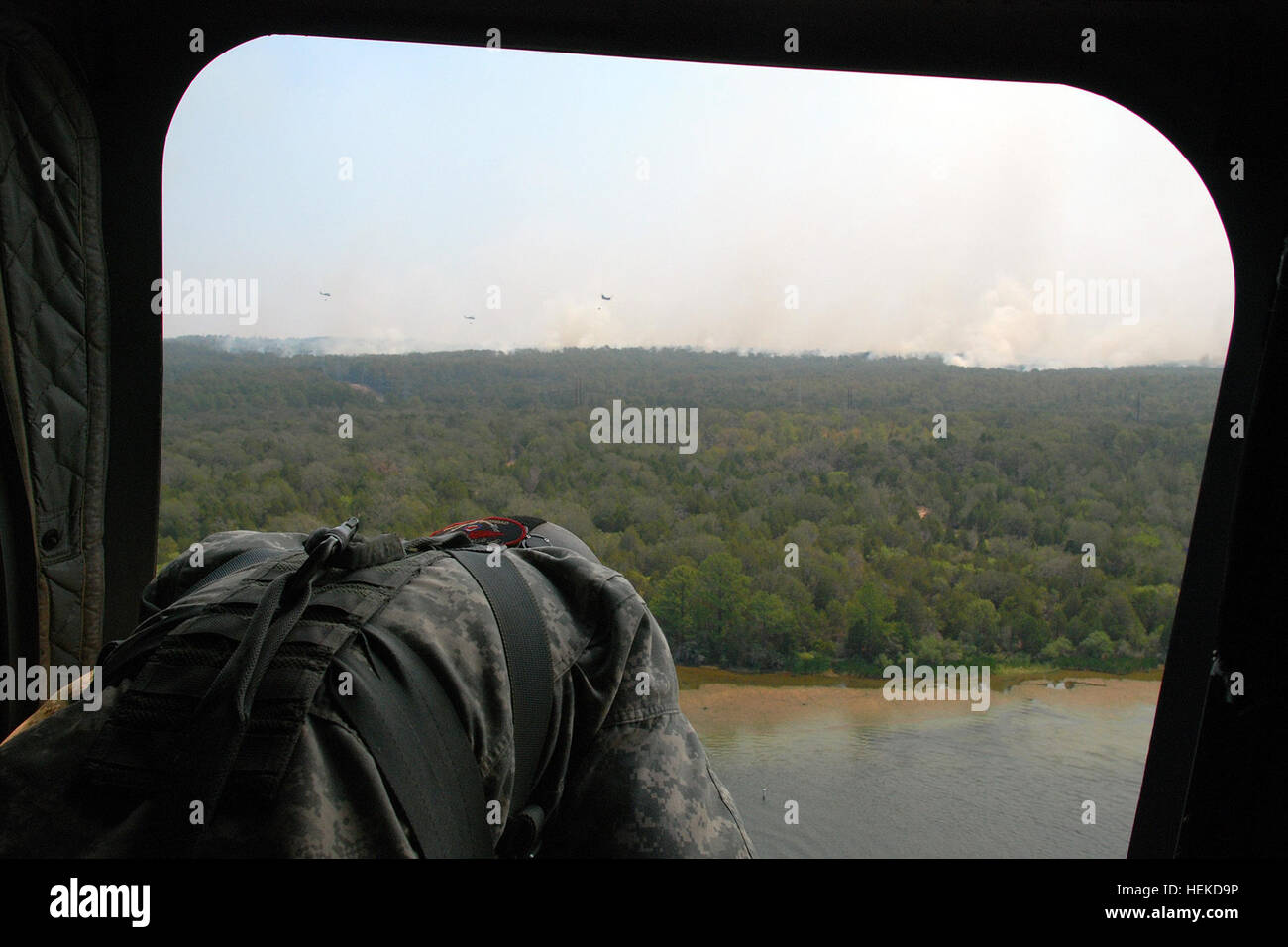 A CH-47 Chinook helicopter crew chief looks down at the water source as ...