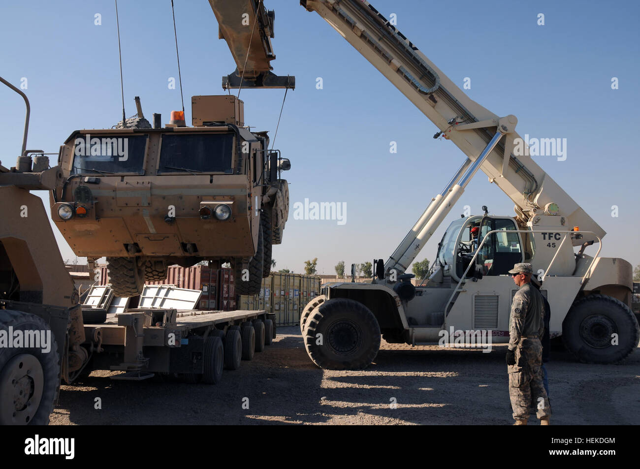 A Heavy Expanded Mobility Tactical Truck is being loaded onto a Heavy ...