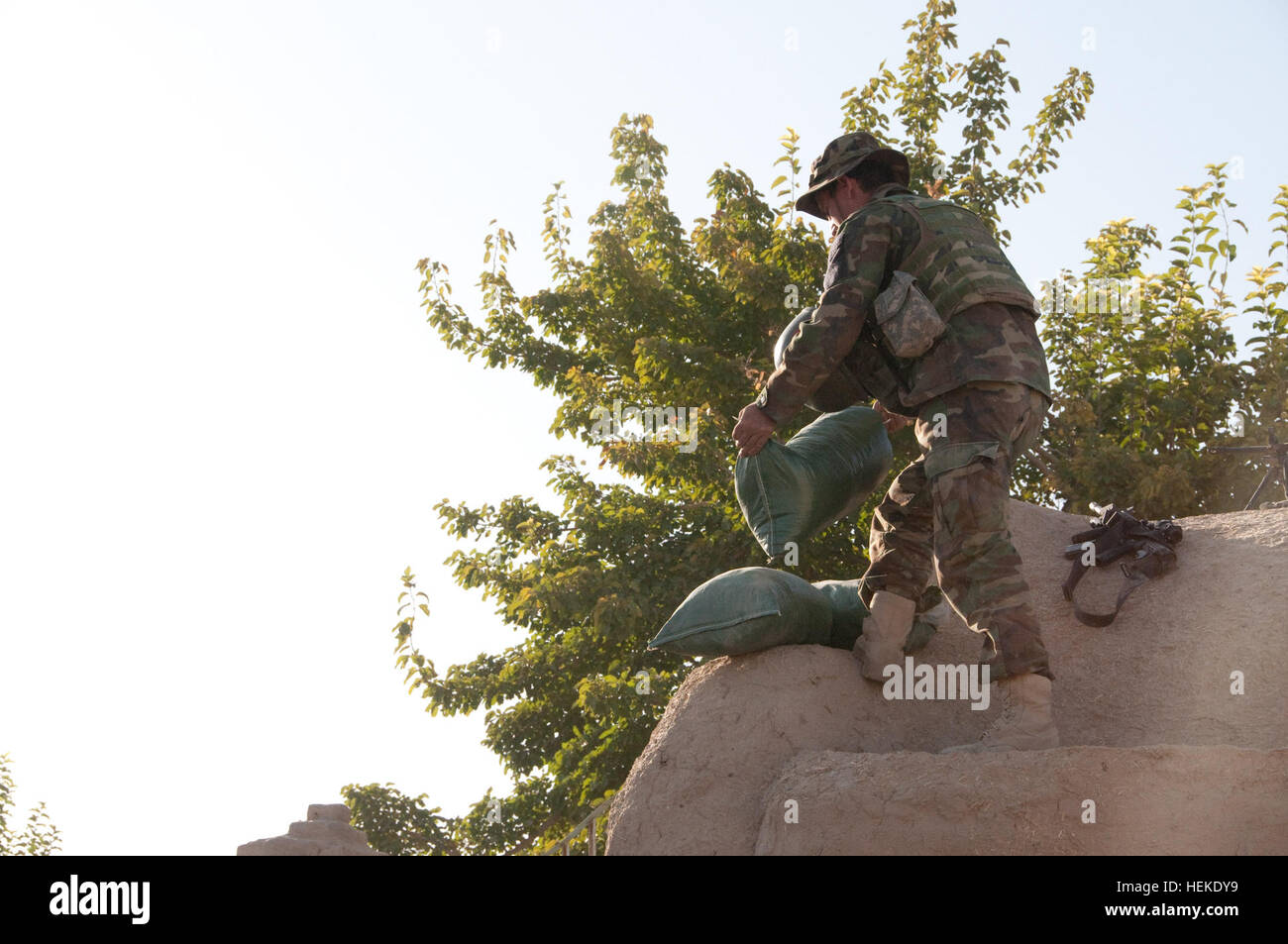 An Afghan National Army Commando reinforces a fighting position with ...