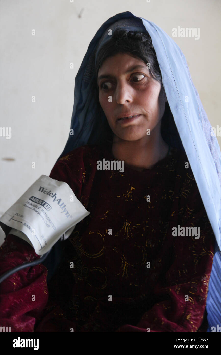 A local Afghan woman known as Bebe looks at the blood pressure cuff on ...