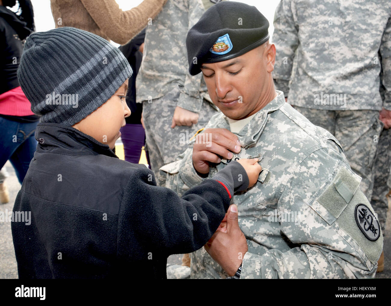Four-year old Sean Leyva, left, pins air assault wings on his father ...