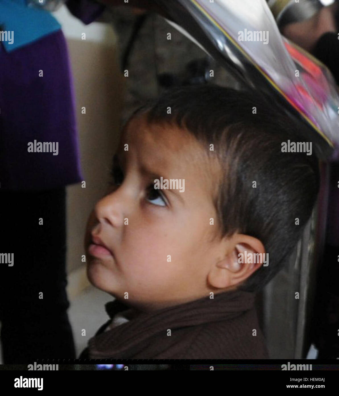 An Afghan boy looks up at an interpreter while waiting to receive ...