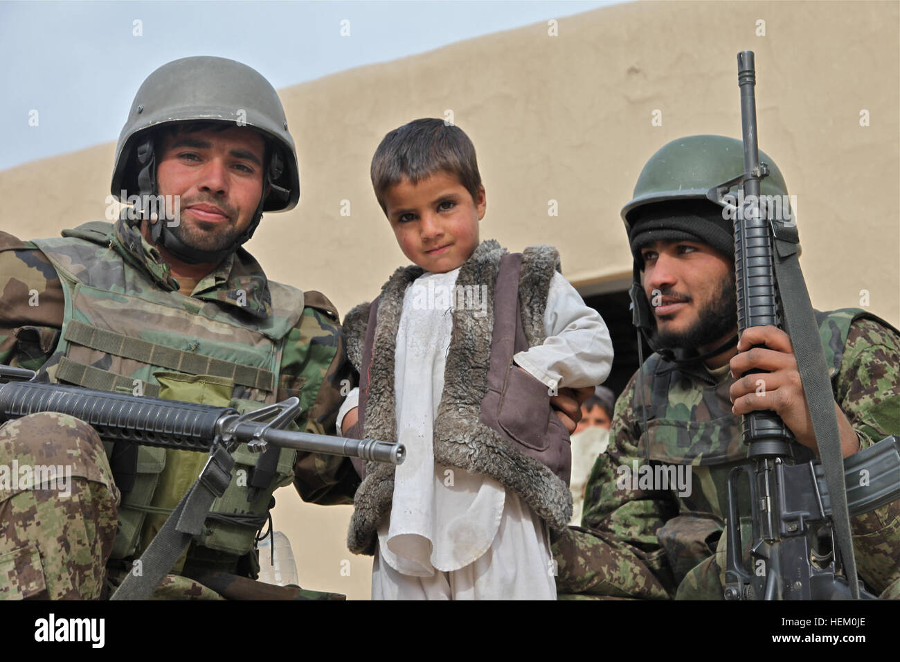 Afghan soldiers pose for a picture with a local Afghan boy, center, at ...