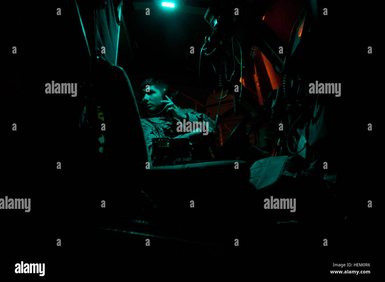 Illuminated by his armored vehicle's green combat lights, Spc. Tom ...