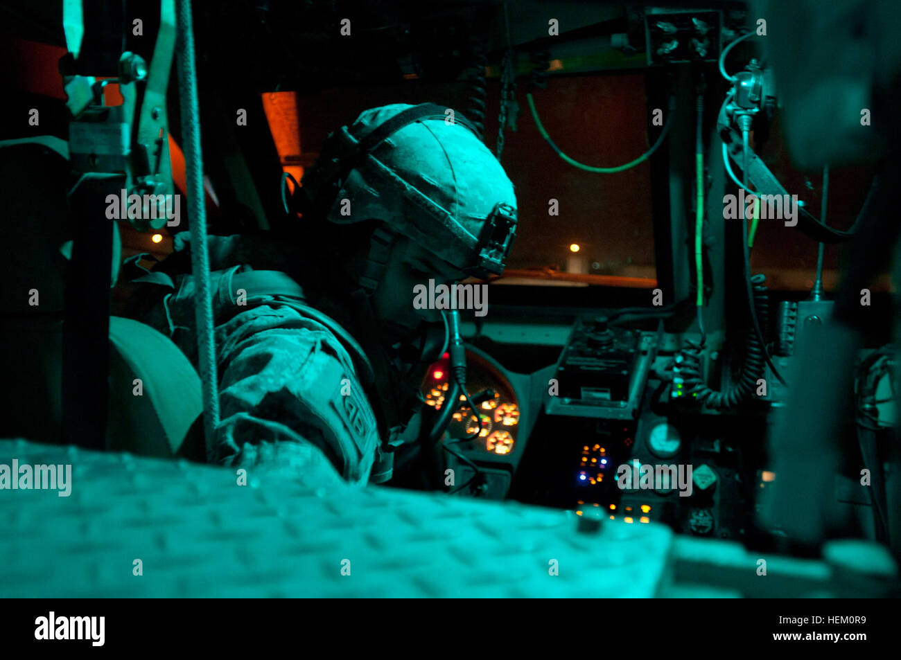 Illuminated by his armored vehicle's green combat lights, Spc. Tom ...