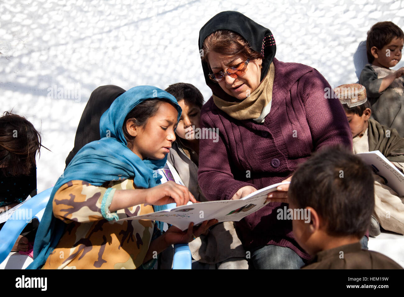 Syria, right, an interpreter, reads to local children at the women's ...