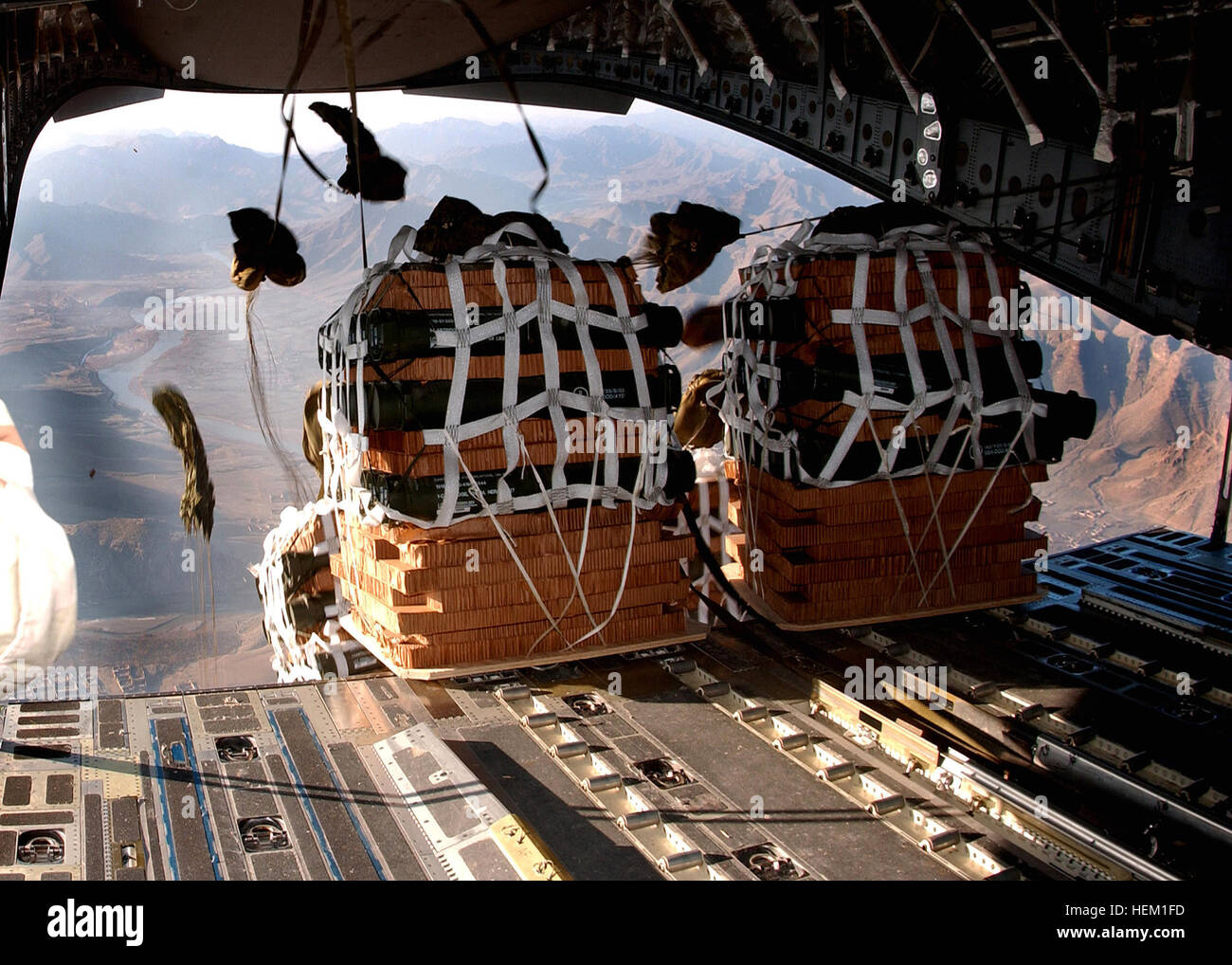 Parachutes begin to open on supply pallets being airdropped from a C-17 ...