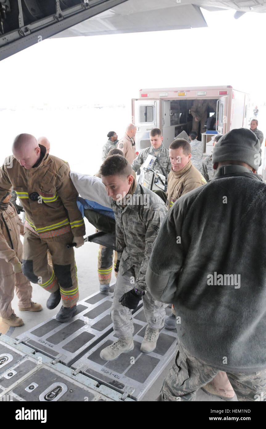 A patient being carried by team members is loaded into the back of the ...