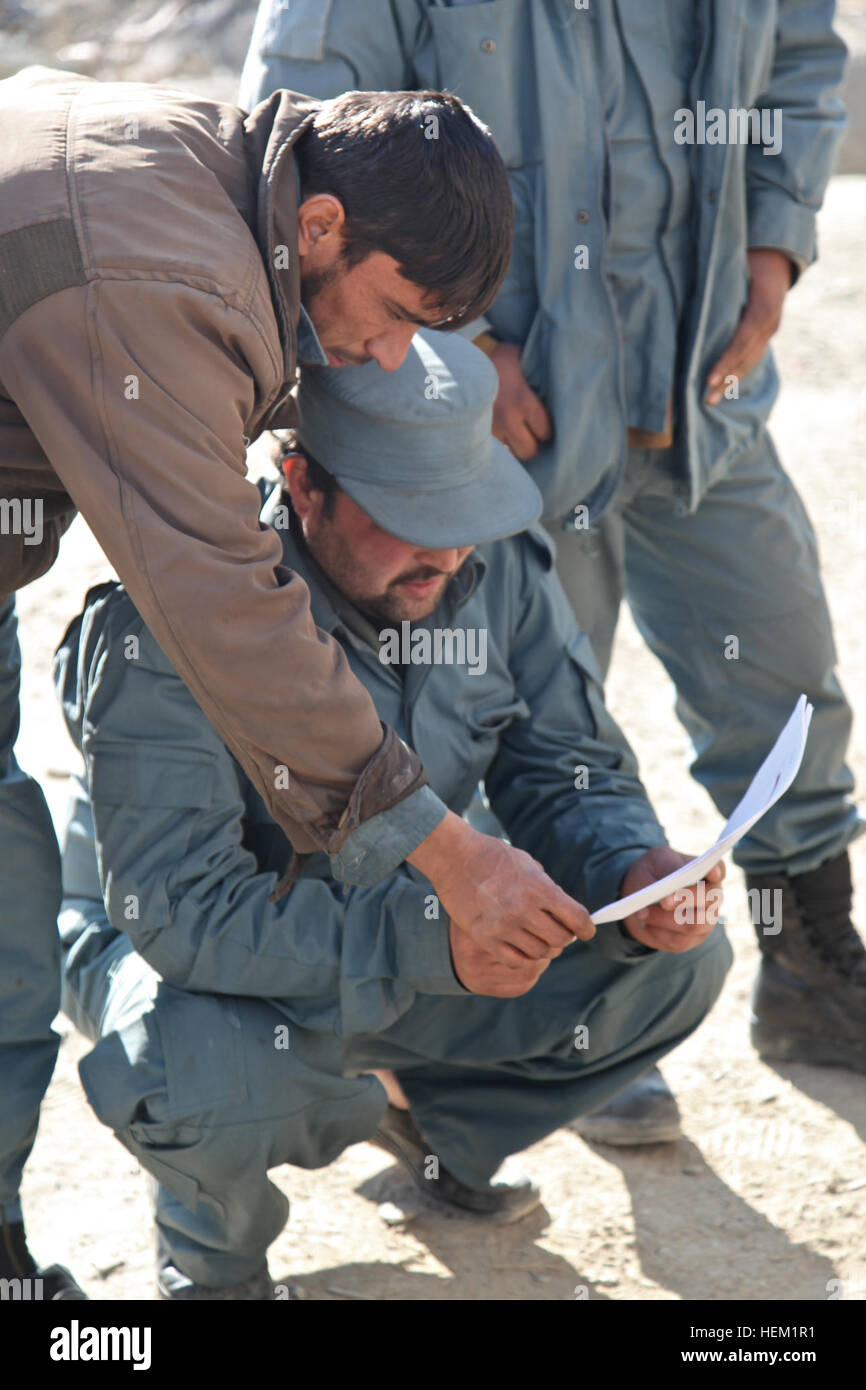 Afghan Uniform Police officers consult a training manual during a class ...