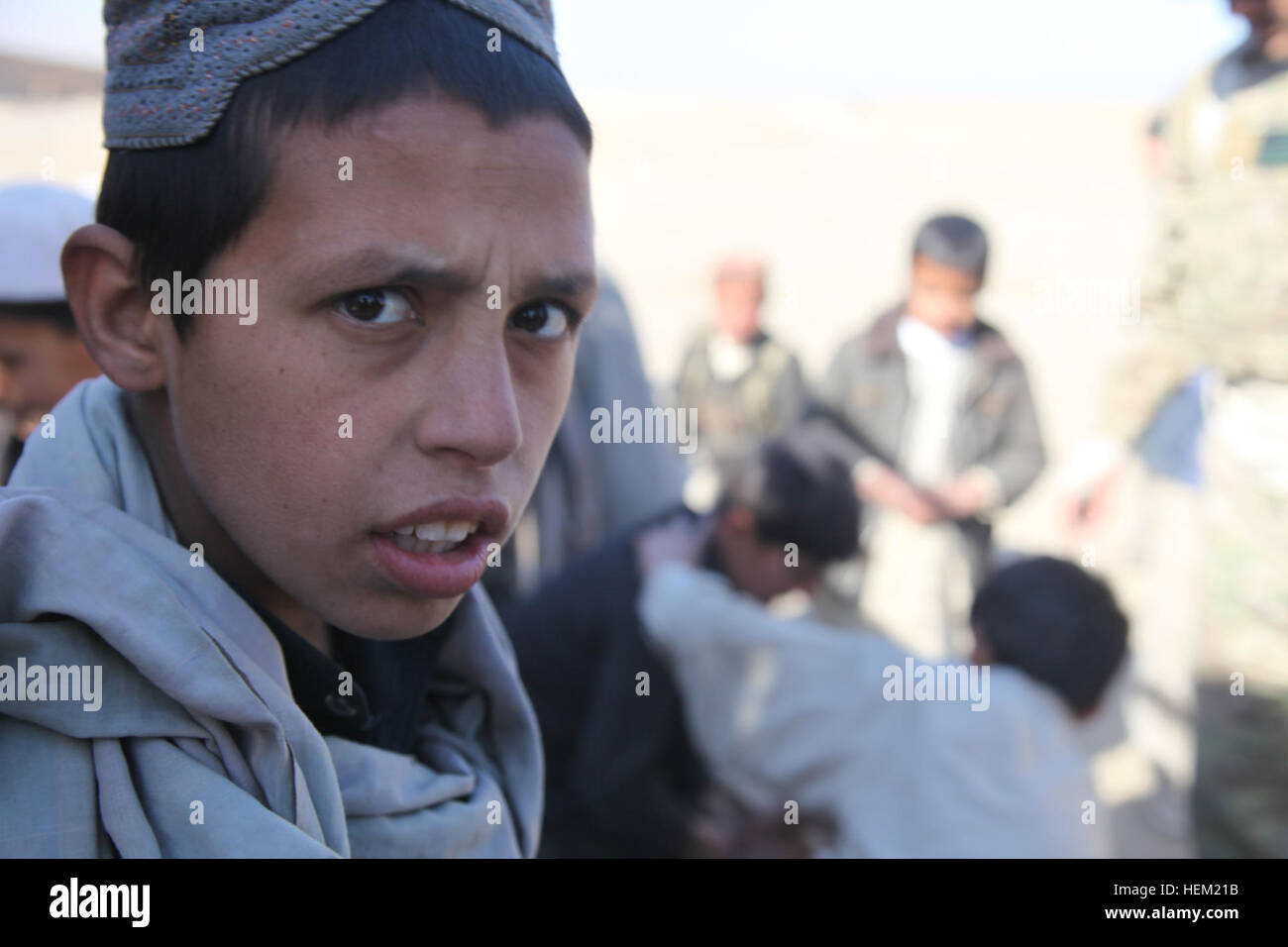 An Afghan boy looks at the camera as children gather around U.S ...