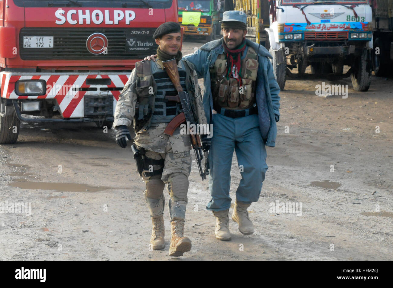 Two Afghan National Security Forces personnel walk side-by-side and ...