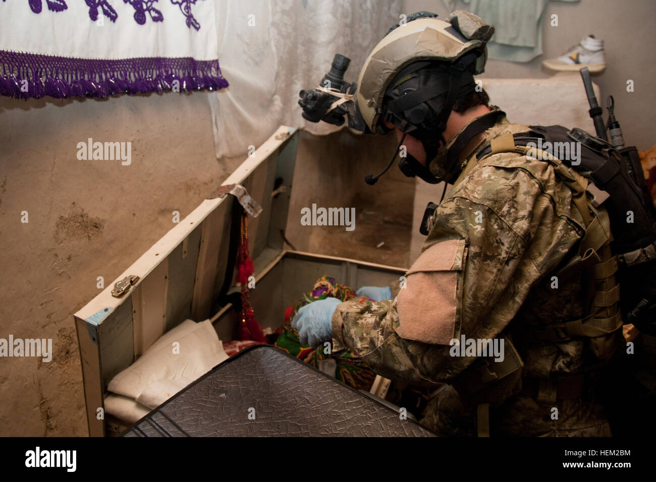 An Afghan and coalition security force member conducts a search that ...