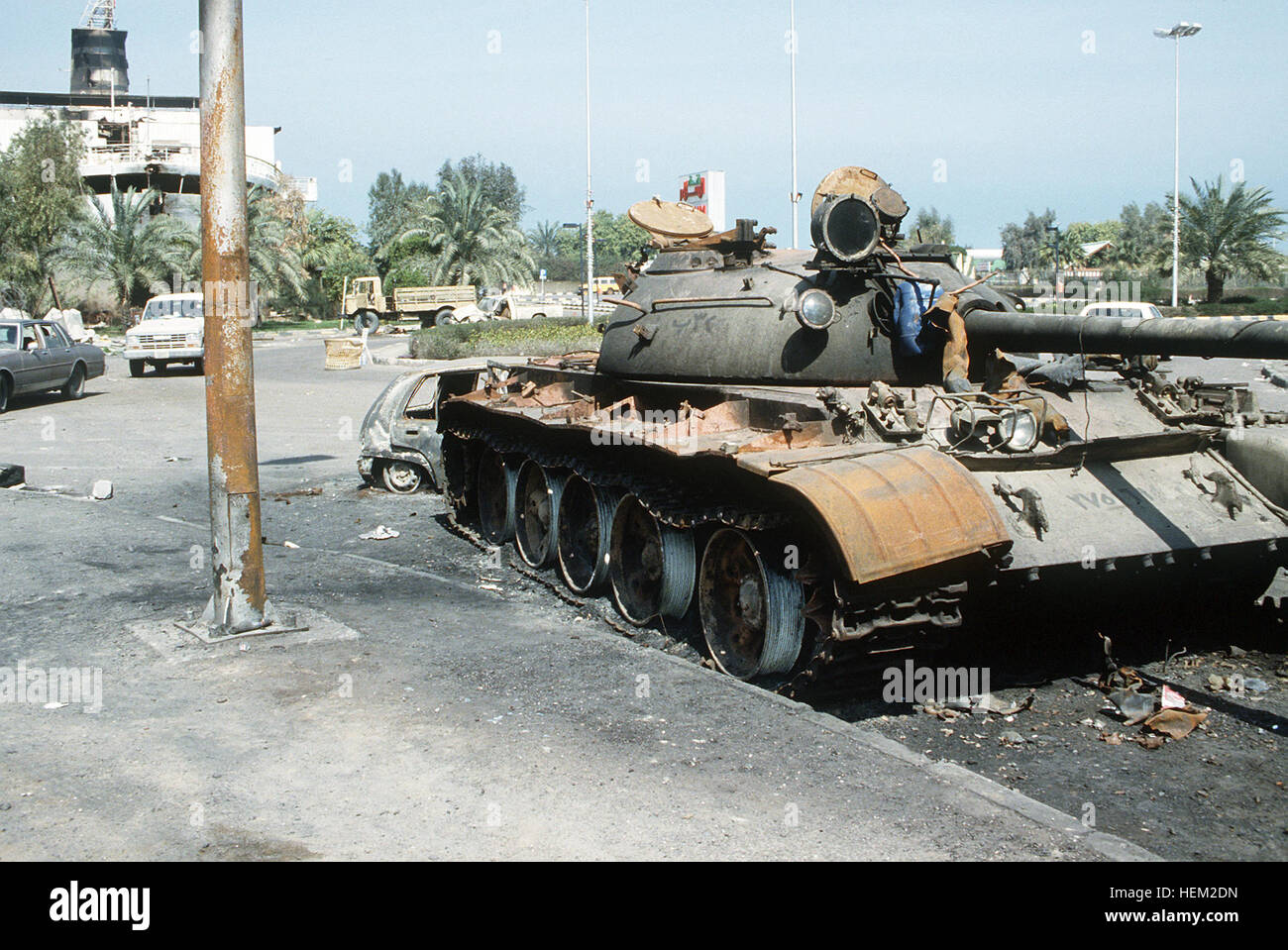 A burned Iraqi T-55 main battle tank and civilian automobile lie along ...