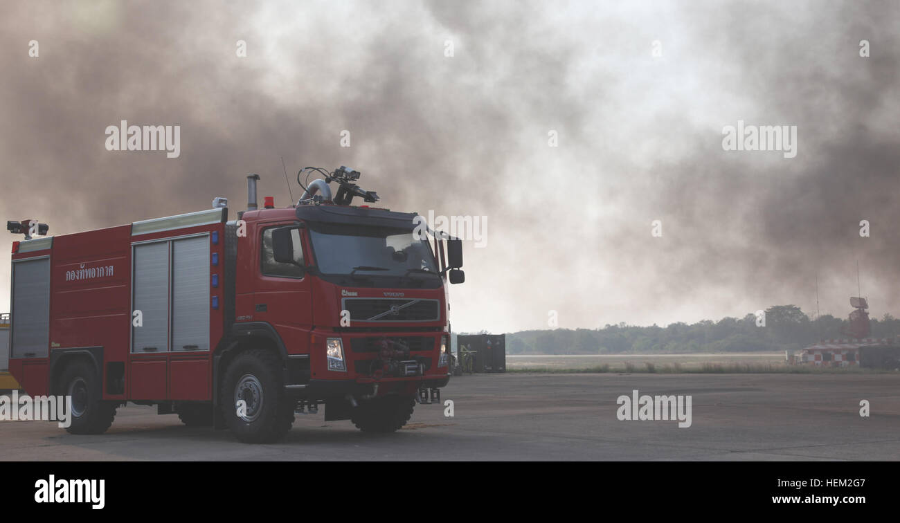 Royal Thai Air Force fire fighters use their fire truck for its hose as ...