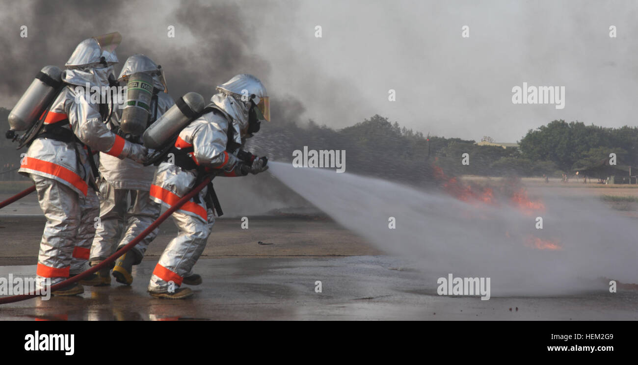 Royal Thai air force fire fighters spray water over gasoline during a ...