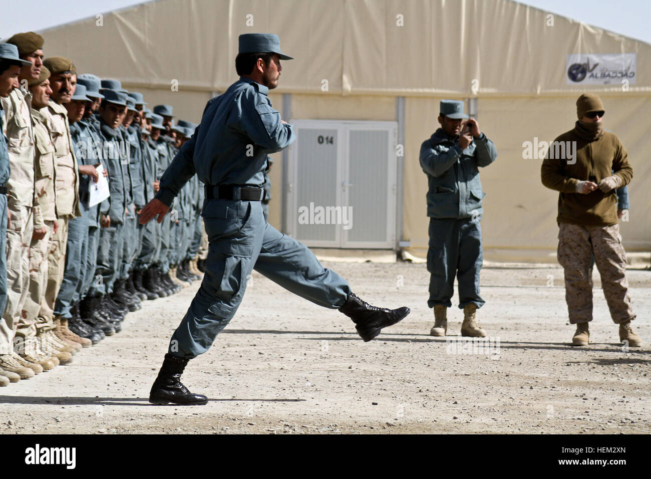 An Afghan National Police officer marches up to accept his diploma ...