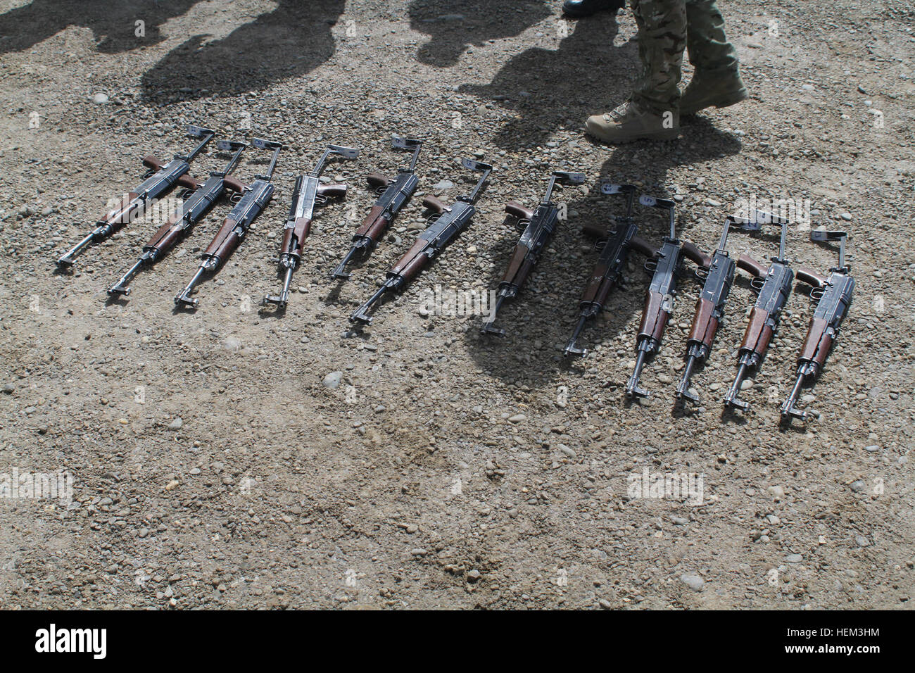 AK-47 rifles, made in the Czech Republic, lie on the ground after a ...