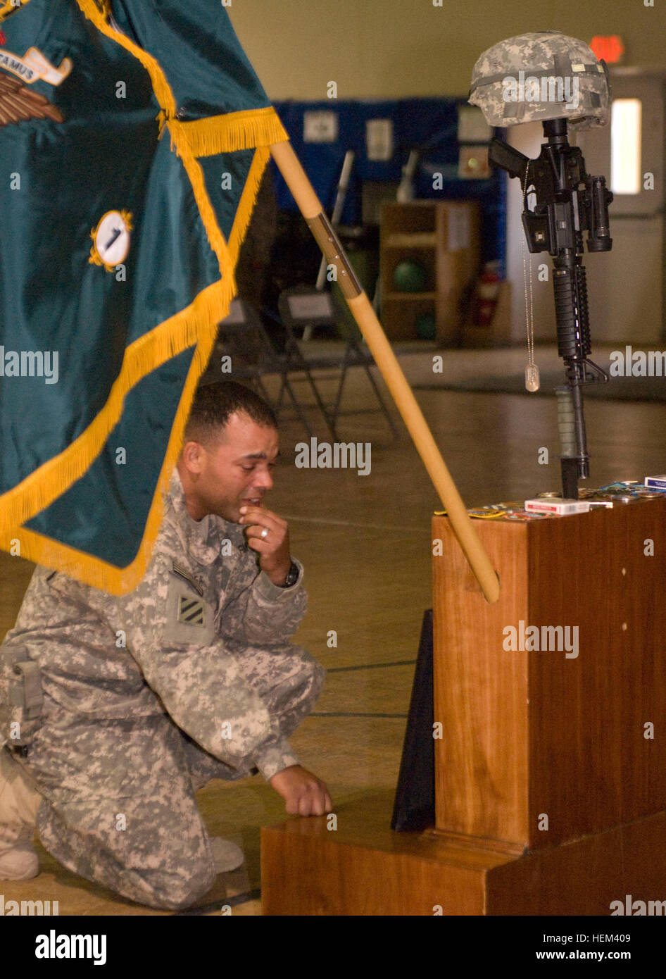 A Soldier kneels in front of the "Battle Cross" of Spc. Stanley John ...