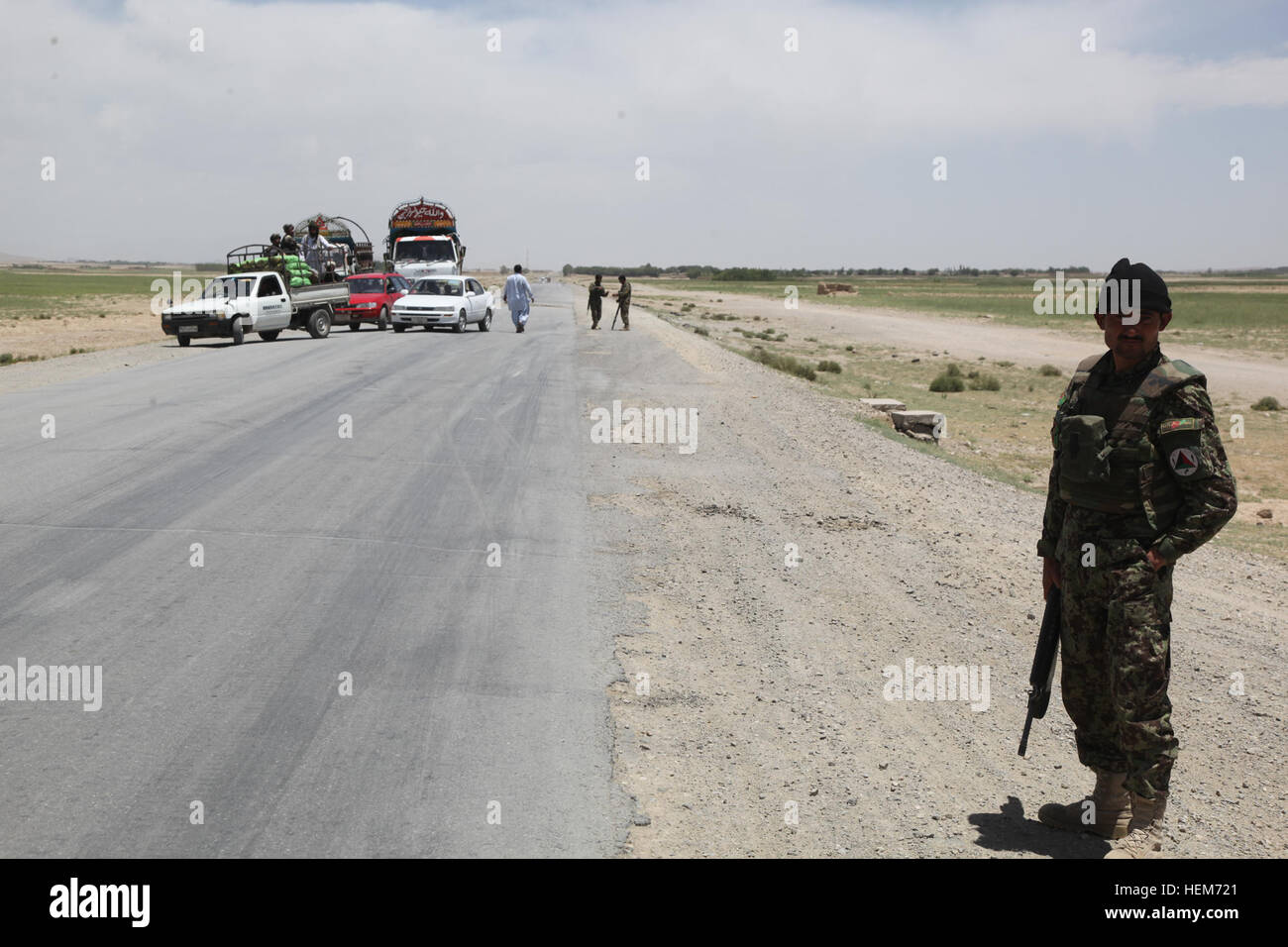 An Afghan National Army soldier keeps civilians back from a controlled ...
