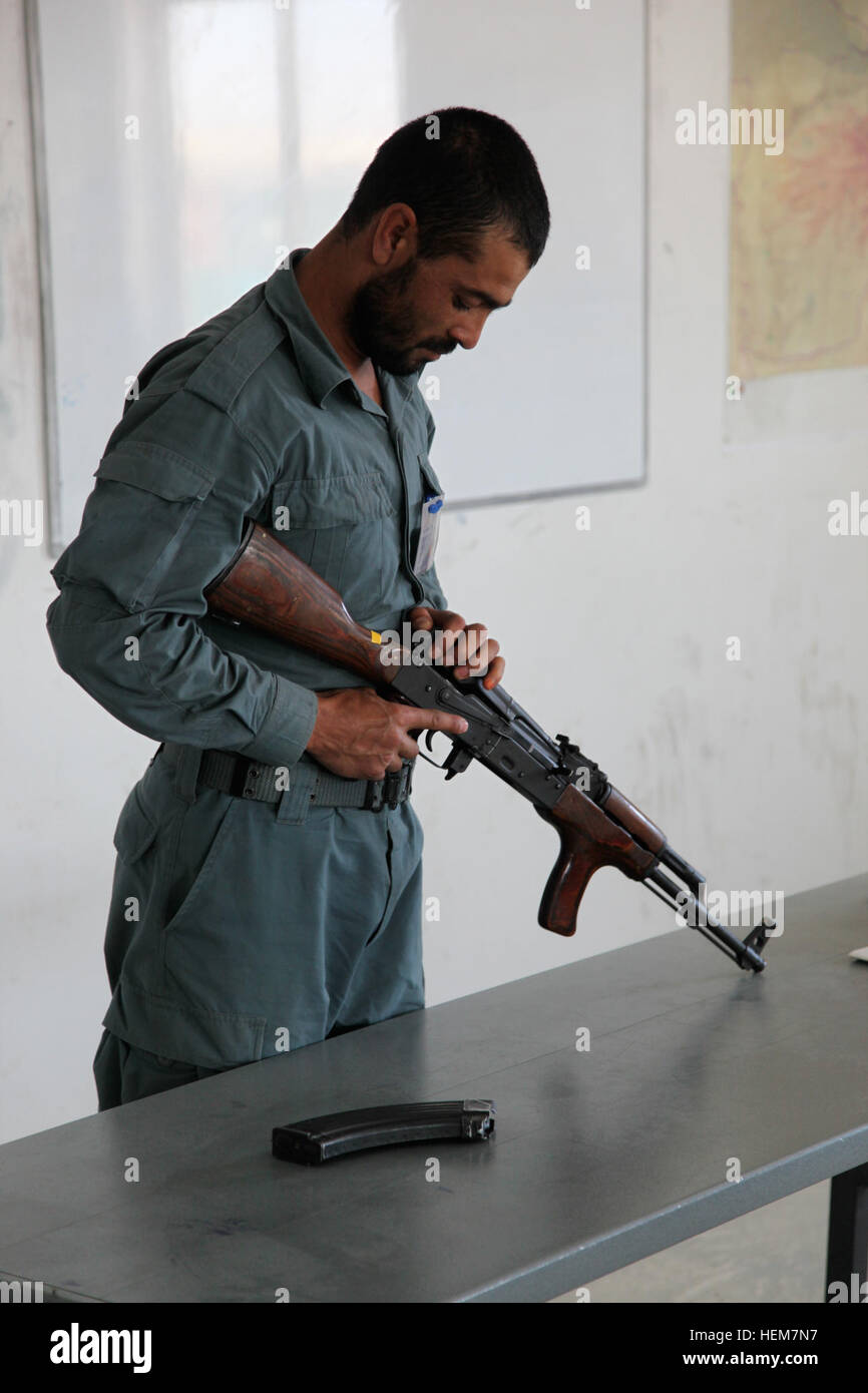 An Afghan Uniform Police recruit takes apart an AK-47 assault rifle to ...