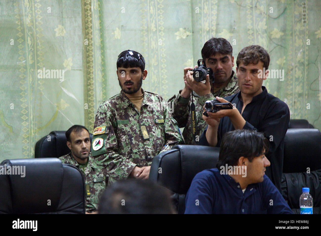 An Afghan National Army public affairs soldier takes photos during a ...