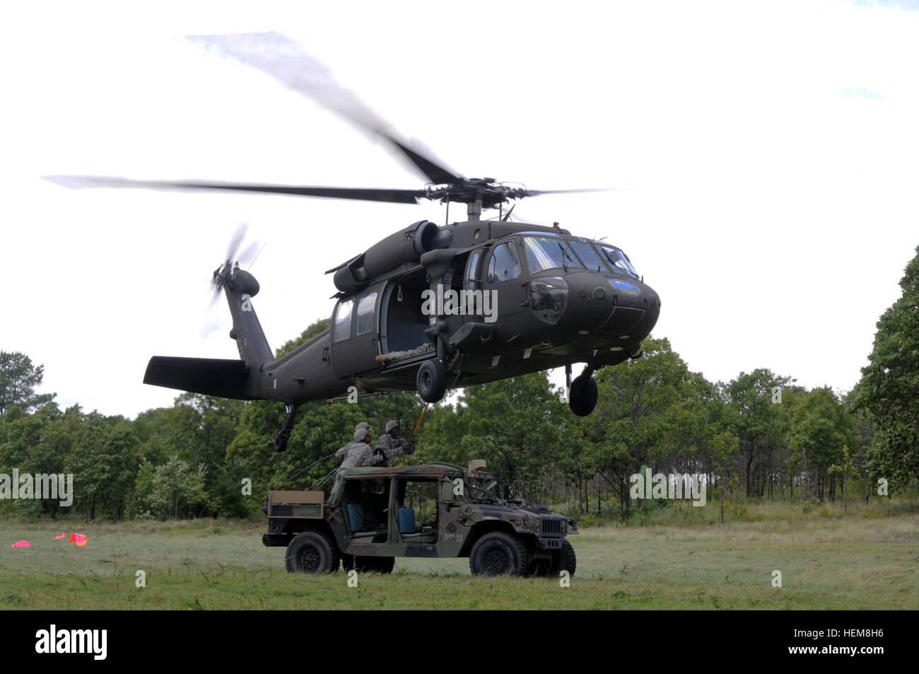 A paratrooper touches a grounding rod to the underside of a UH-60 Black ...