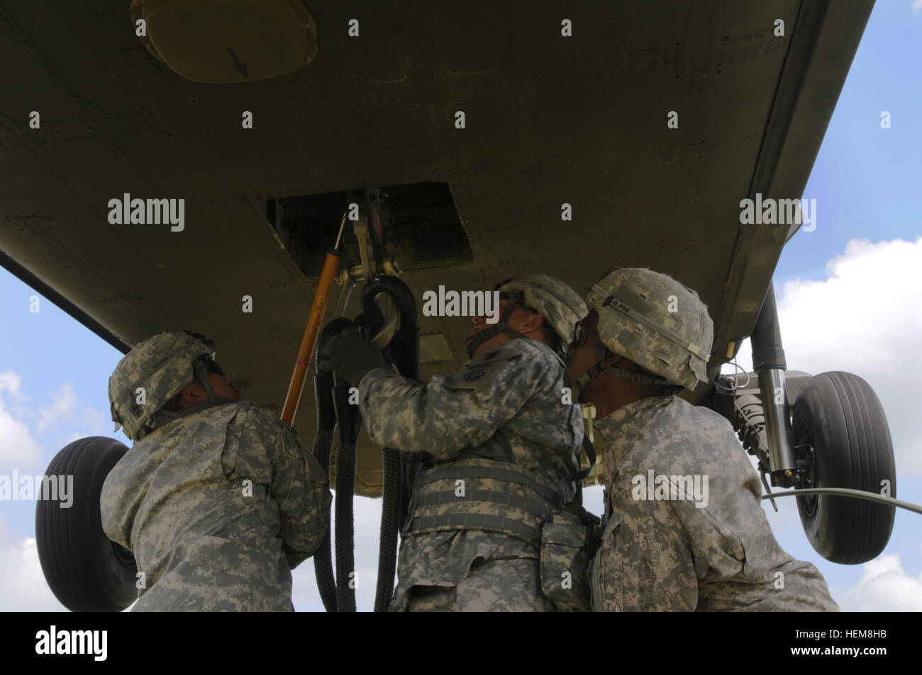 Paratroopers hook a sling-loaded Humvee to the underside of a UH-60 ...