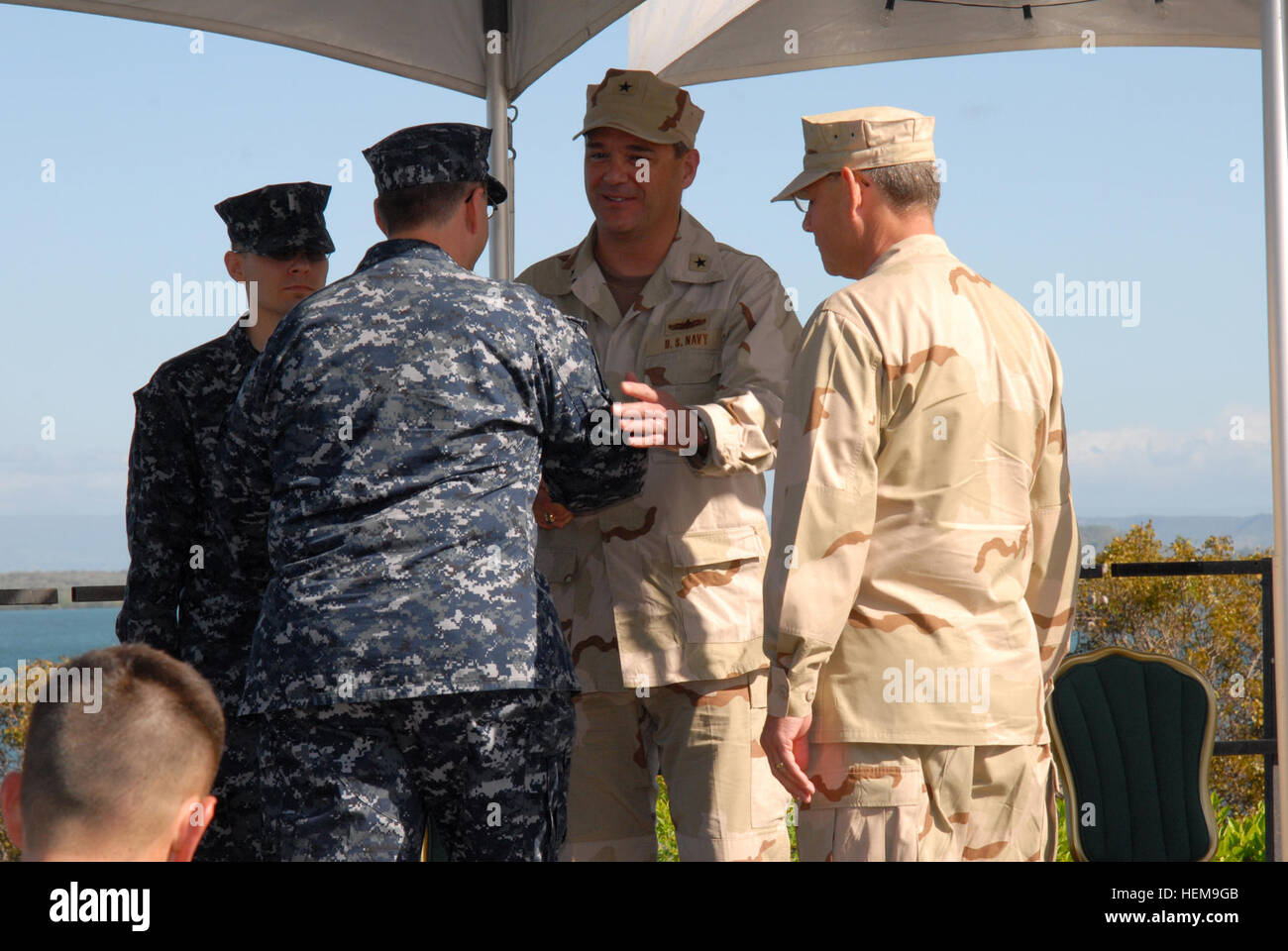 Navy Rear Adm. Tom Copeman shakes hands with Navy Capt. David Wright ...
