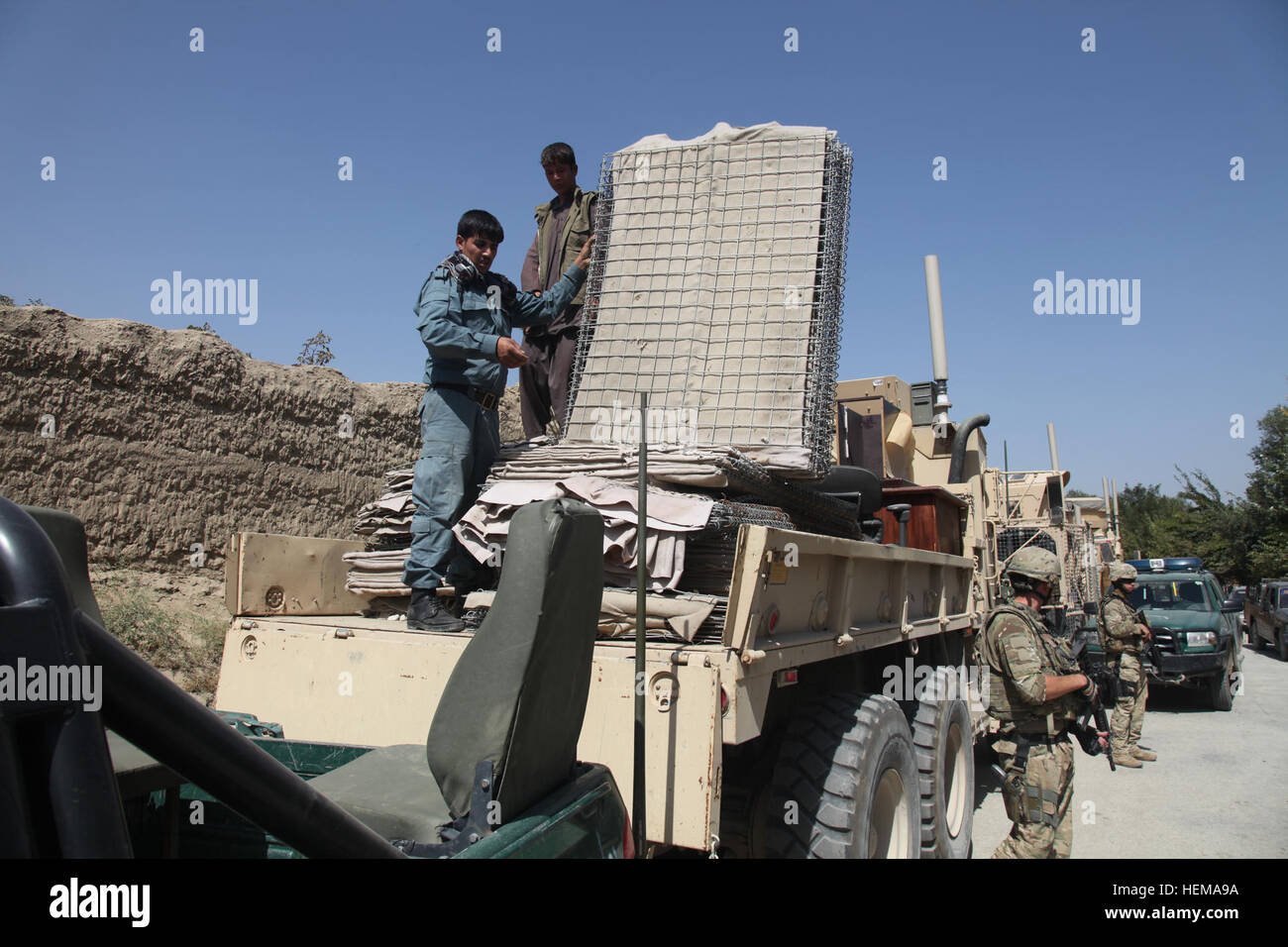 Afghan National Police (ANP) officers unload a Hesco barrier off a ...
