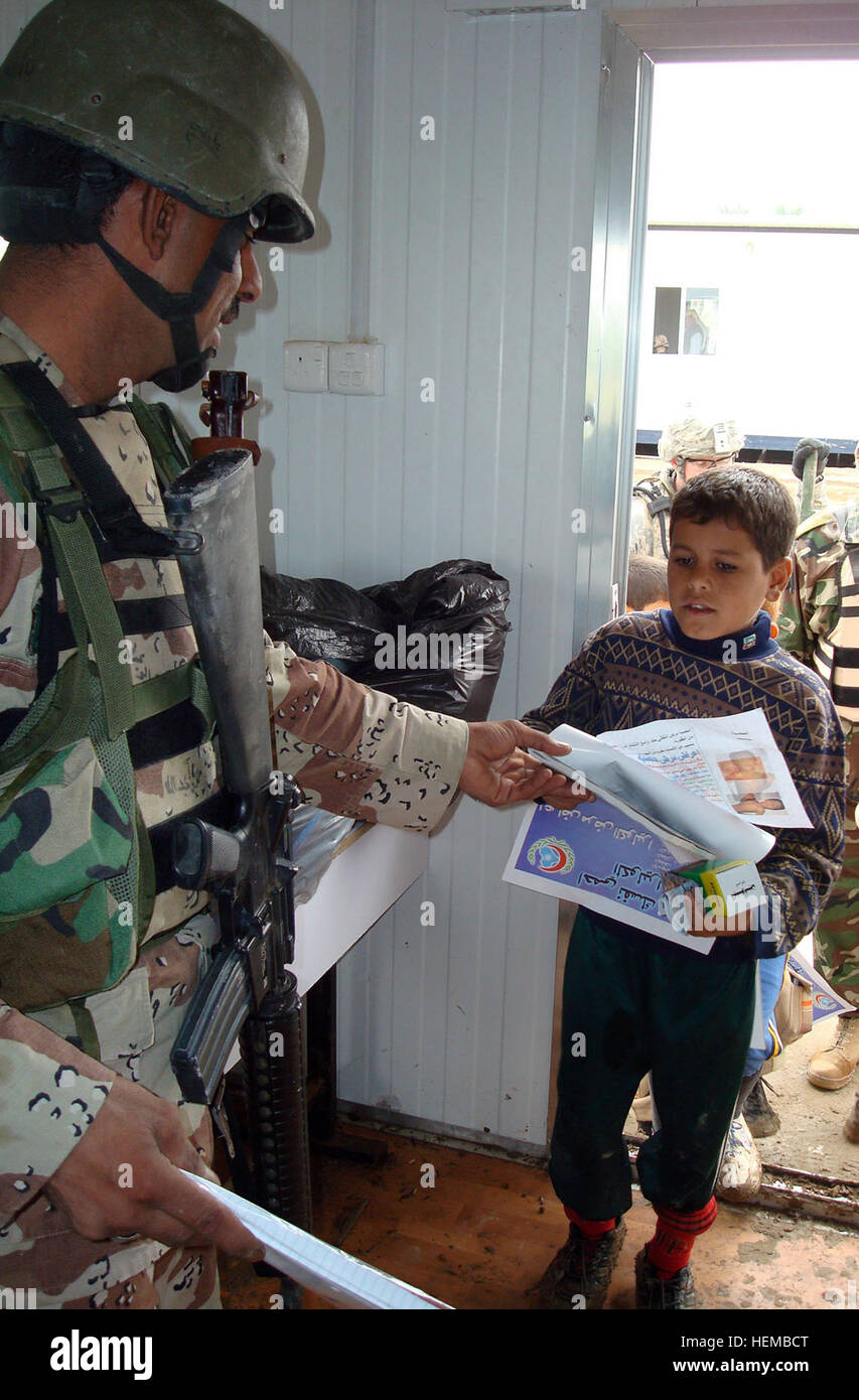 An Iraqi army soldier hands out posters with hygiene instructions to ...