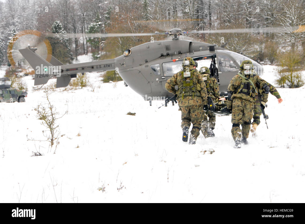 Polish army soldiers carry a Romanian soldier to a UH-72 Lakota ...