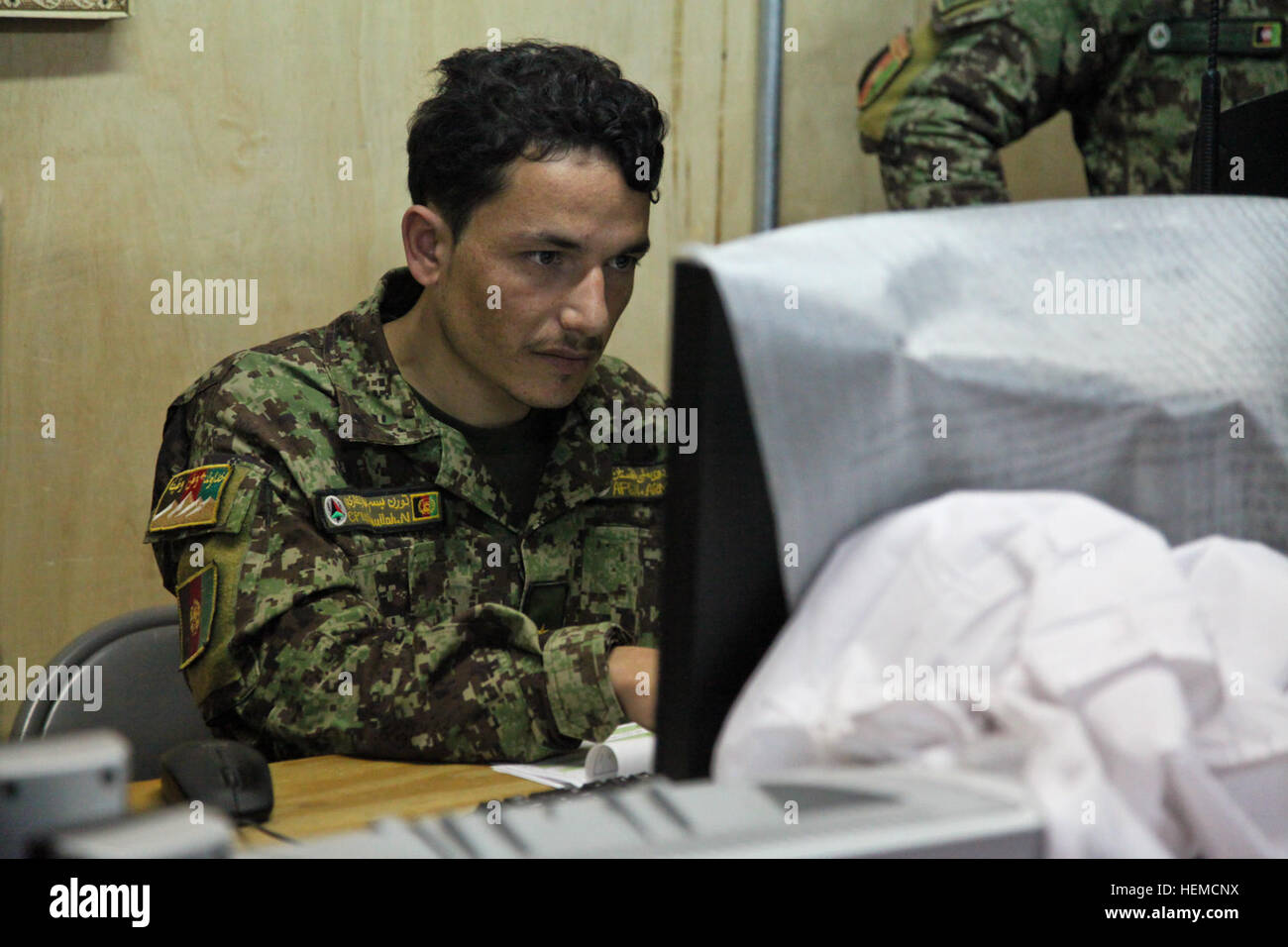 An Afghan National Army (ANA) soldier inputs data into his computer at ...