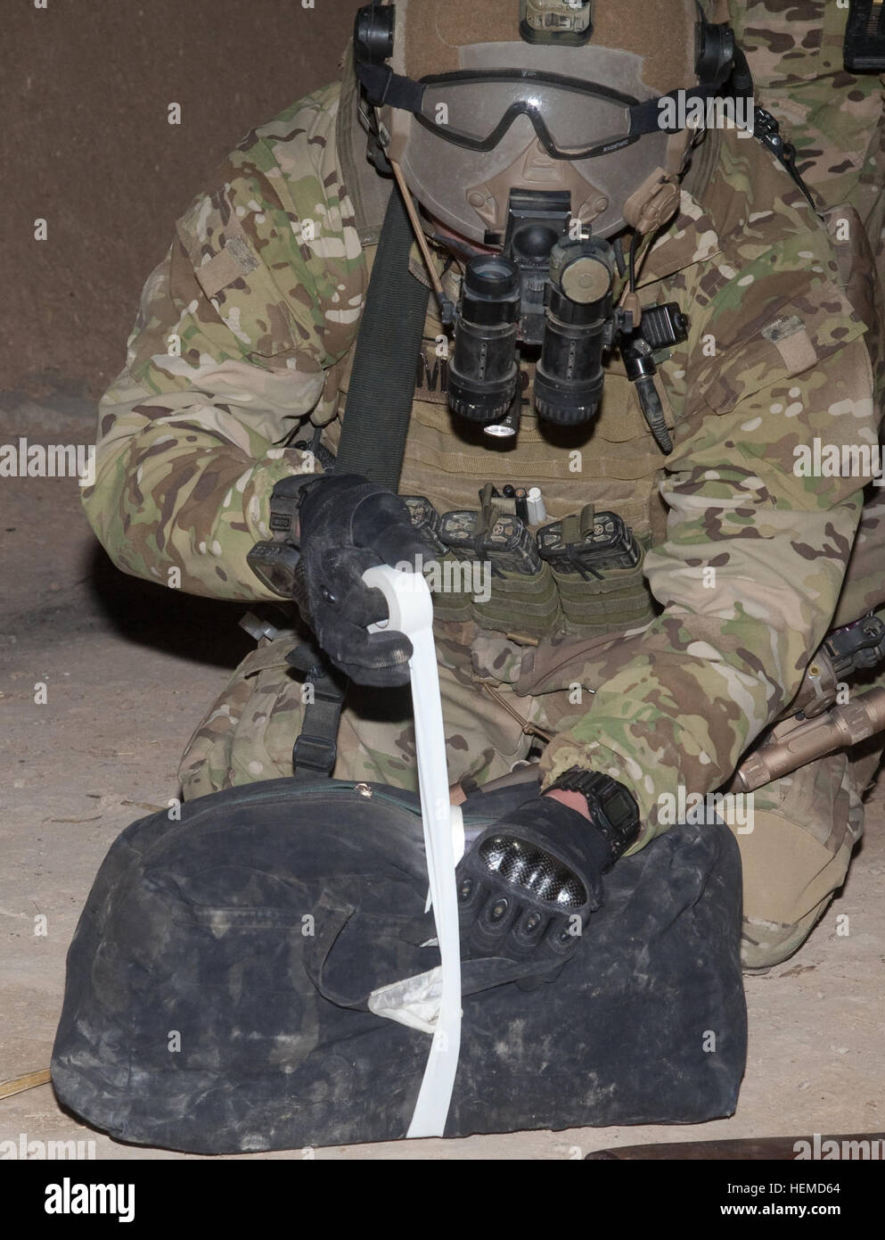 Afghan and coalition forces secure explosive devices and weapons from a ...