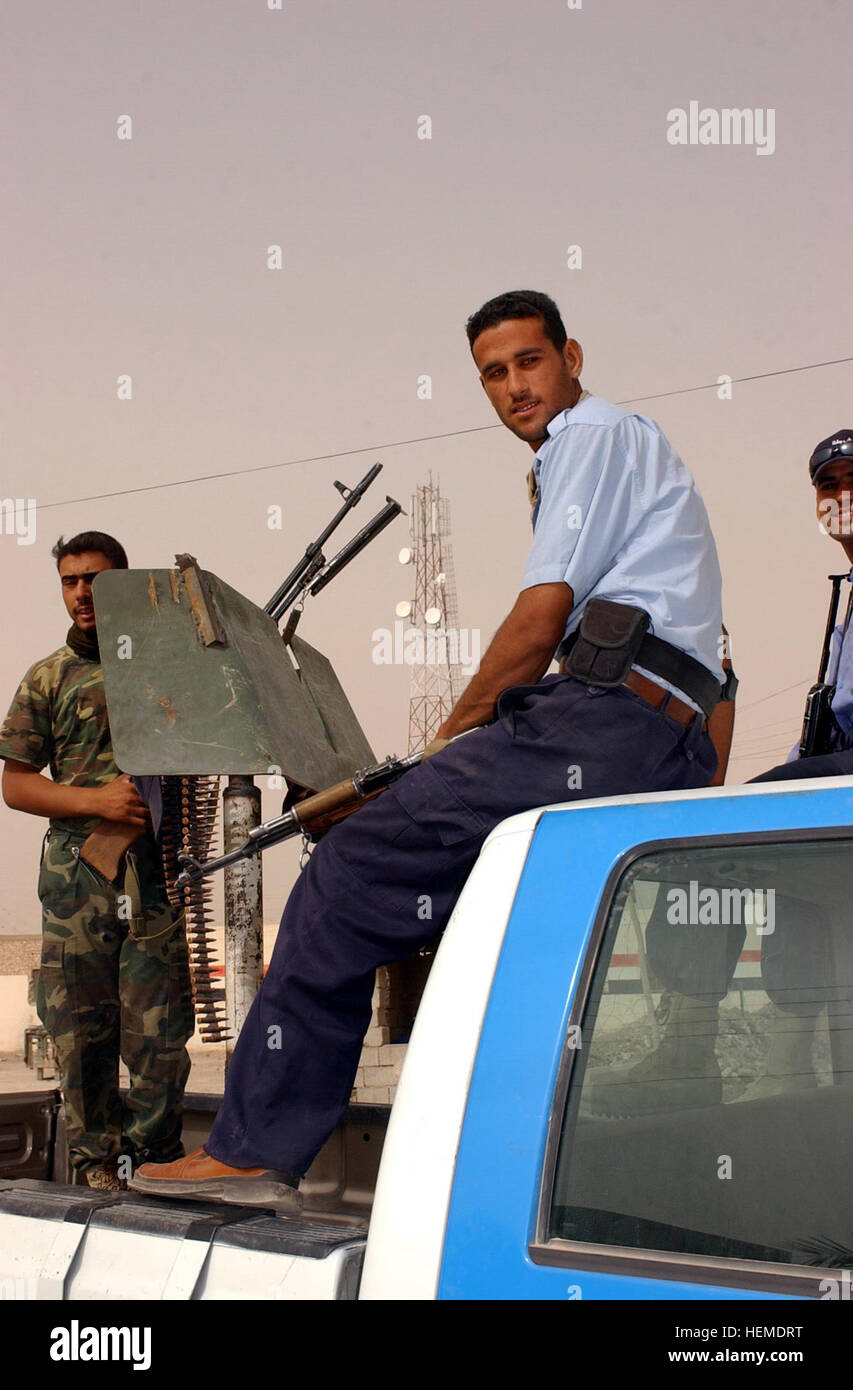 Iraqi police officers ride on the back of a police vehicle at their ...