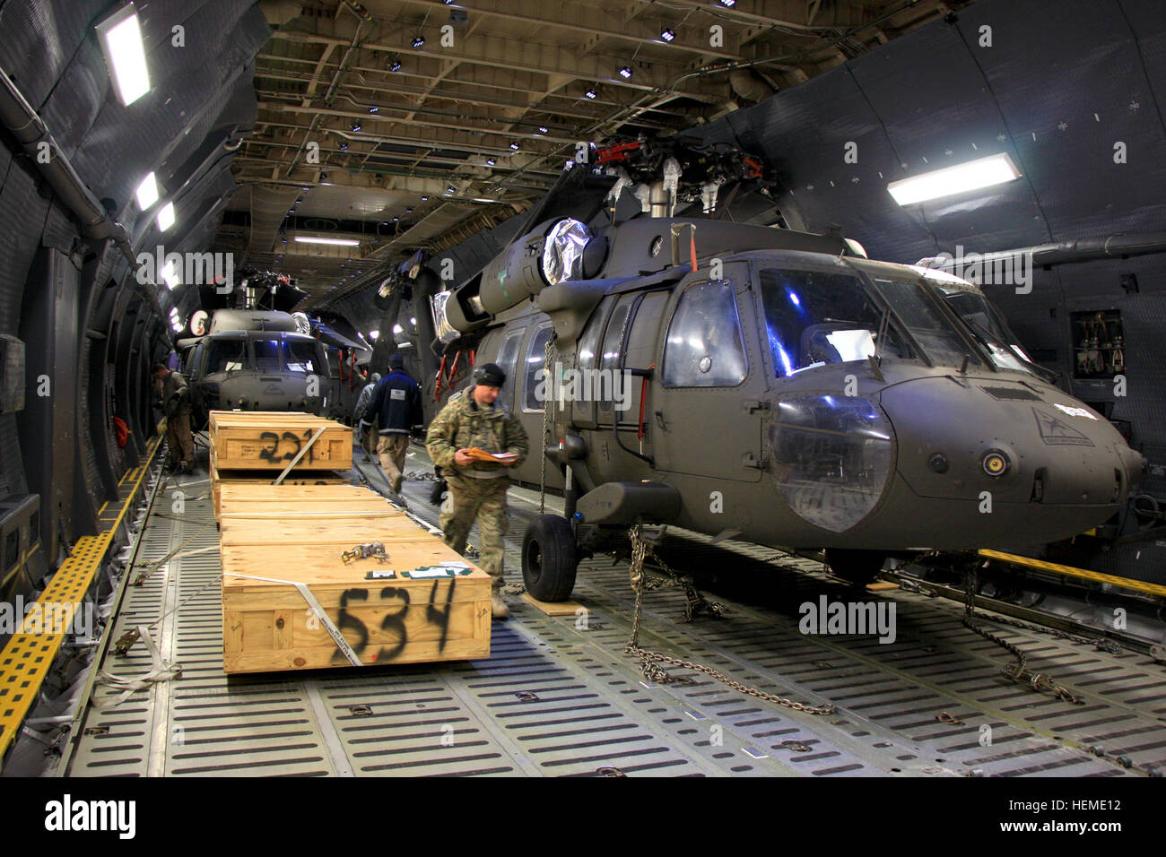 U.S. Army ground crews unload UH-60 Black Hawk helicopters from a C-5 ...