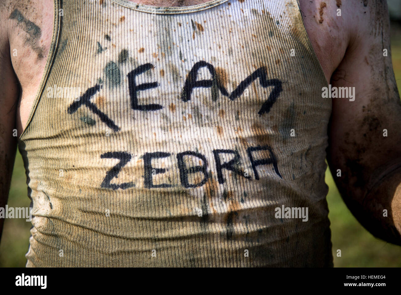 A participant displays his team's name on his soiled shirt during the ...