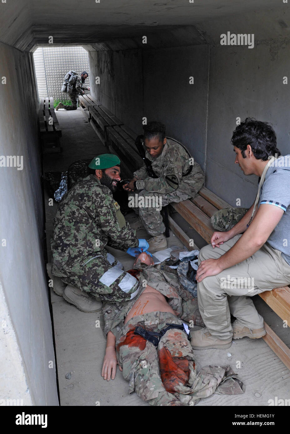 An Afghan National Army (ANA) soldier provides security (top) as an ANA ...